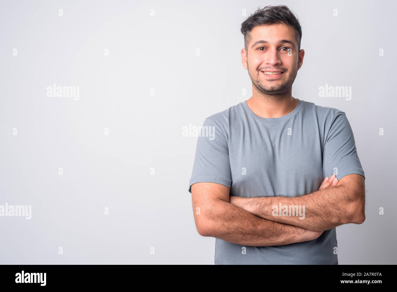 Portrait of happy young Persian man smiling with arms crossed Stock ...