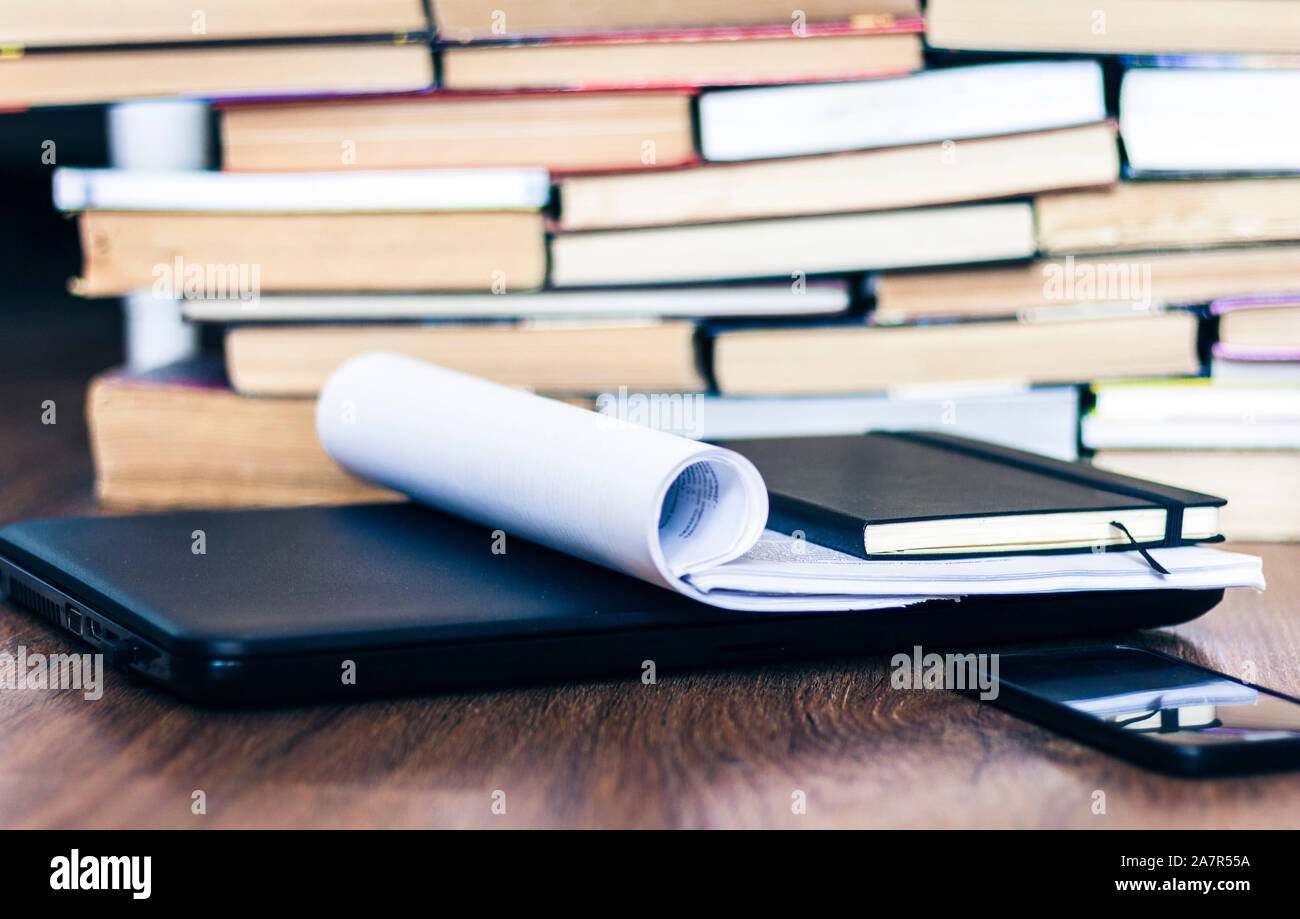 Open textbook, notebook, smartphone, laptop computer, stack of books ...