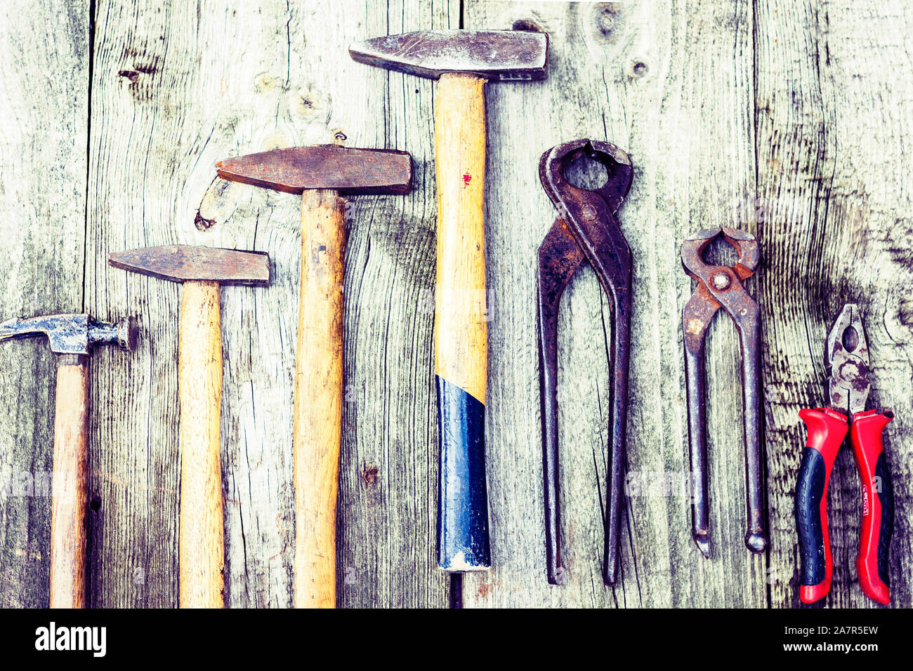 Set of vintage hand construction tools hammers on a wooden background ...
