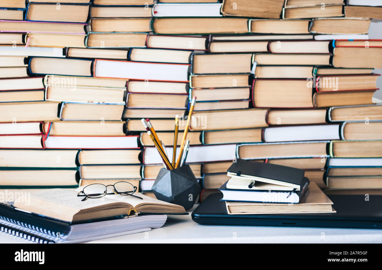 Open textbook, notebook, laptop computer, stack of books education back ...