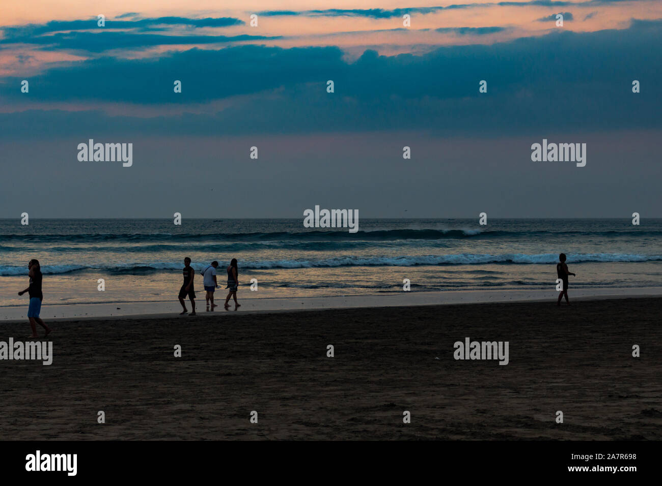 Sunset on the island of Bali, Indonesia. People walk on the beach Stock ...