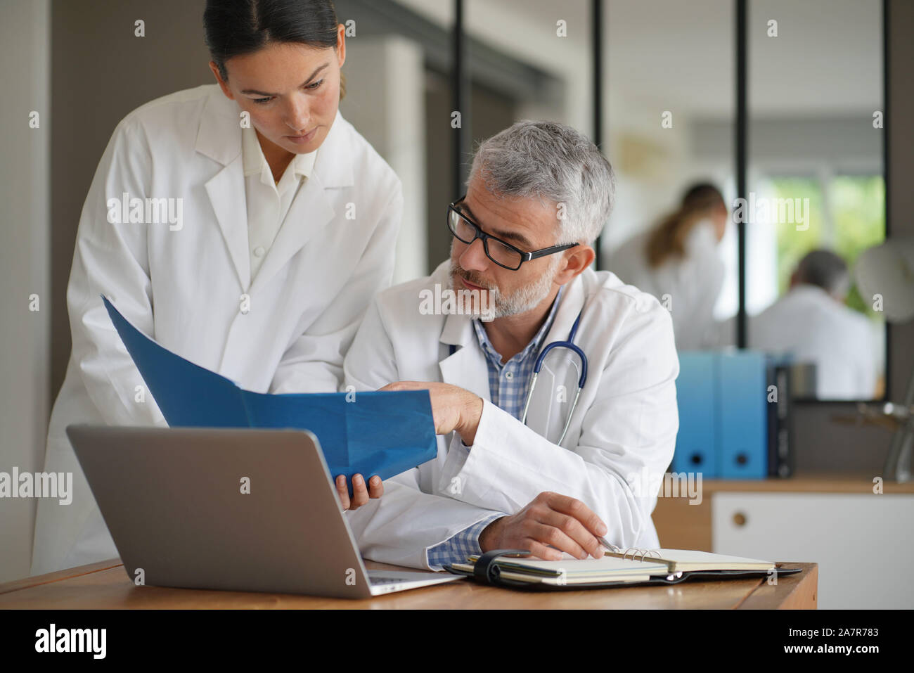 Medical people working together on patient file, hospital office Stock ...