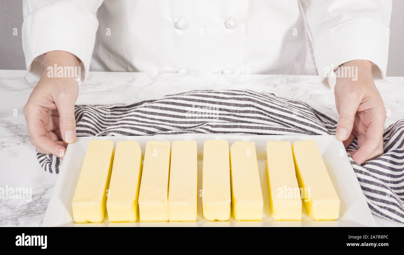 Step by step. Stick of butter at room temperature on a white plate ...