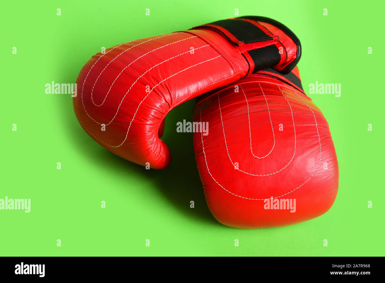 Sport boxing gloves in red colour for martial arts isolated on green ...