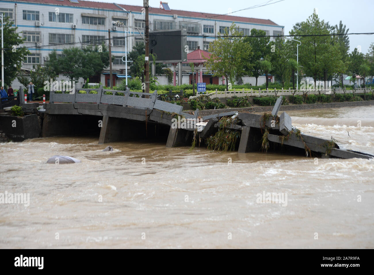 A bridge is devastated by the floodwater due to rainstorms caused by ...