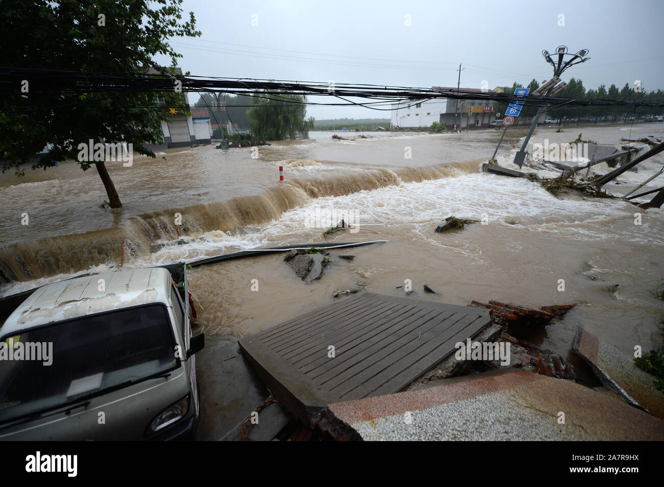 A bridge is devastated by the floodwater due to rainstorms caused by ...