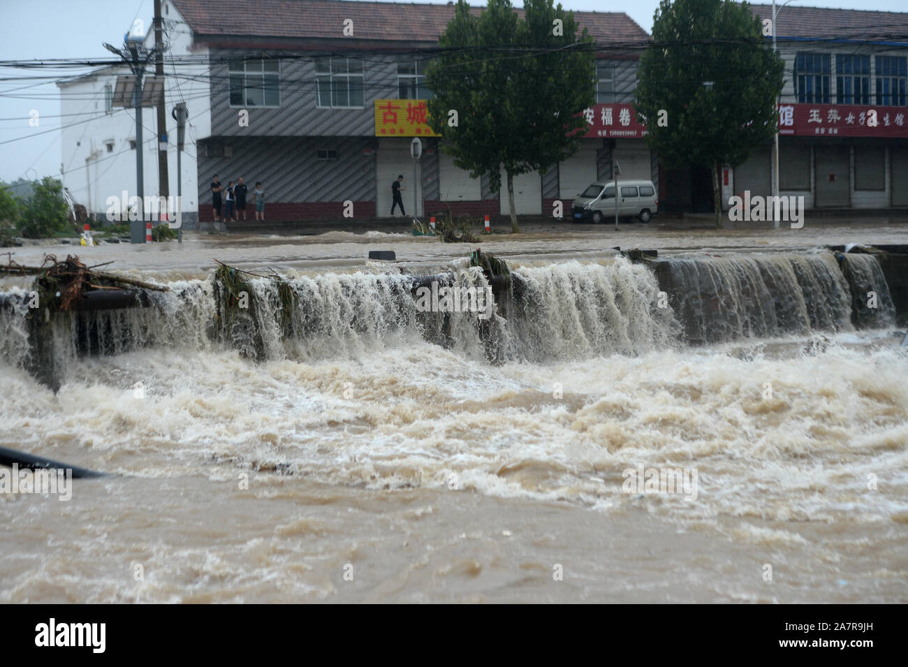A bridge is devastated by the floodwater due to rainstorms caused by ...