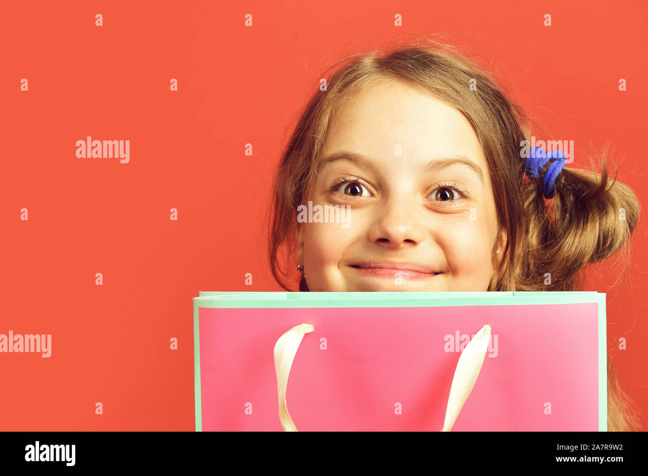 Girl with pink shopping bag. Kid with satisfied face expression and ...