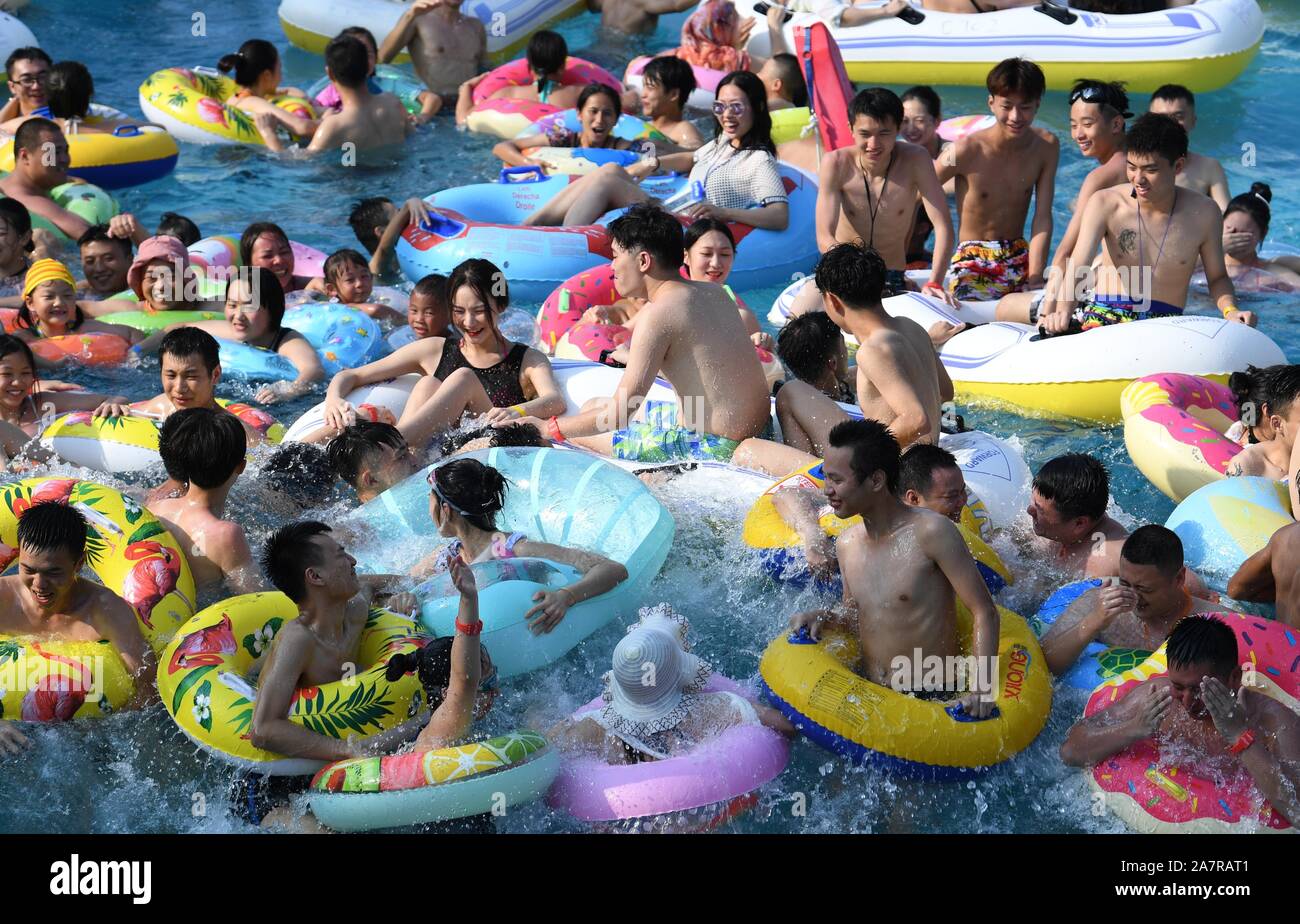 Chinese holidaymakers crowd a swimming pool at a water park to escape ...
