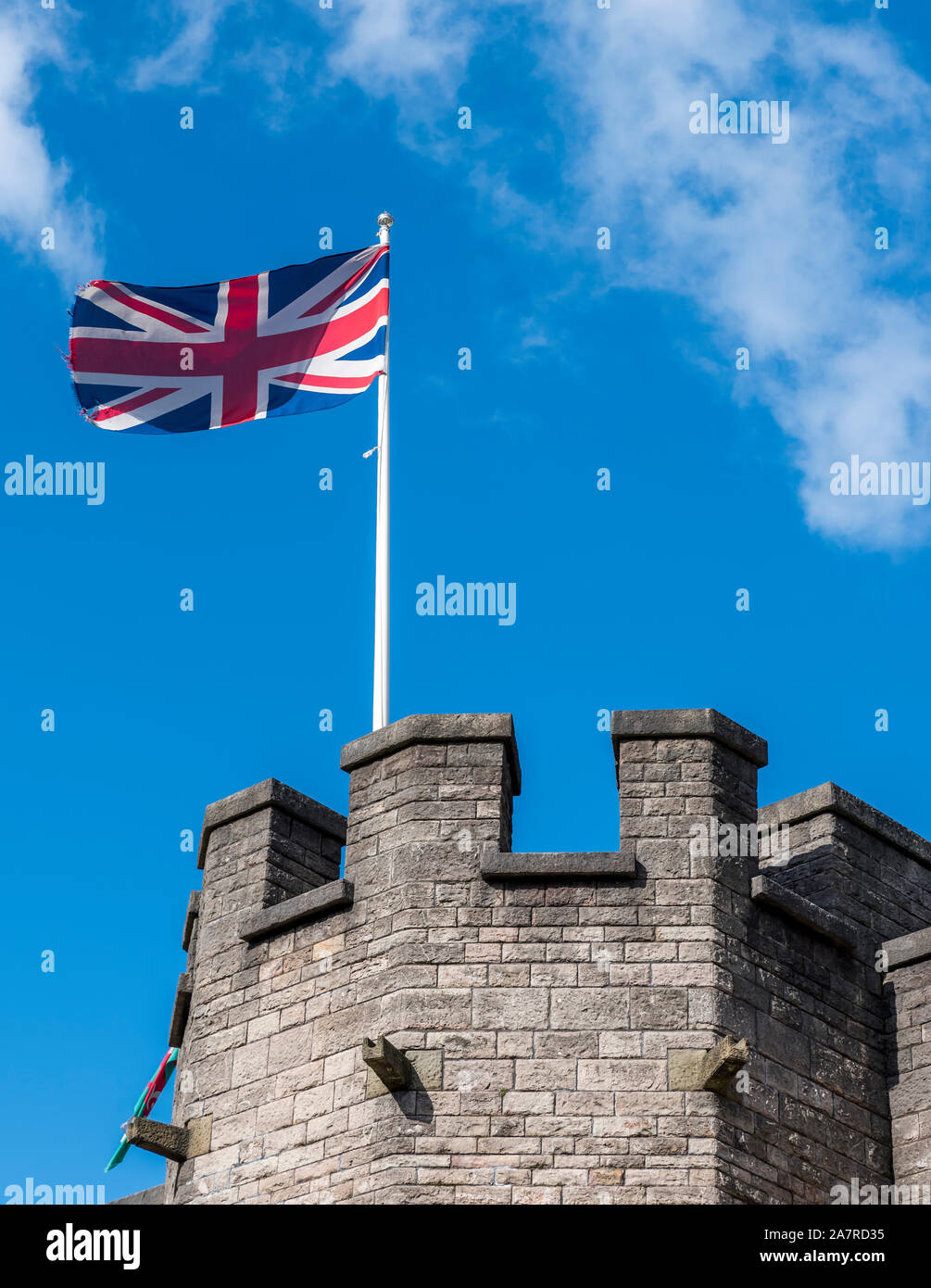 The union flag flying above castle ramparts, against a deep blue sky ...