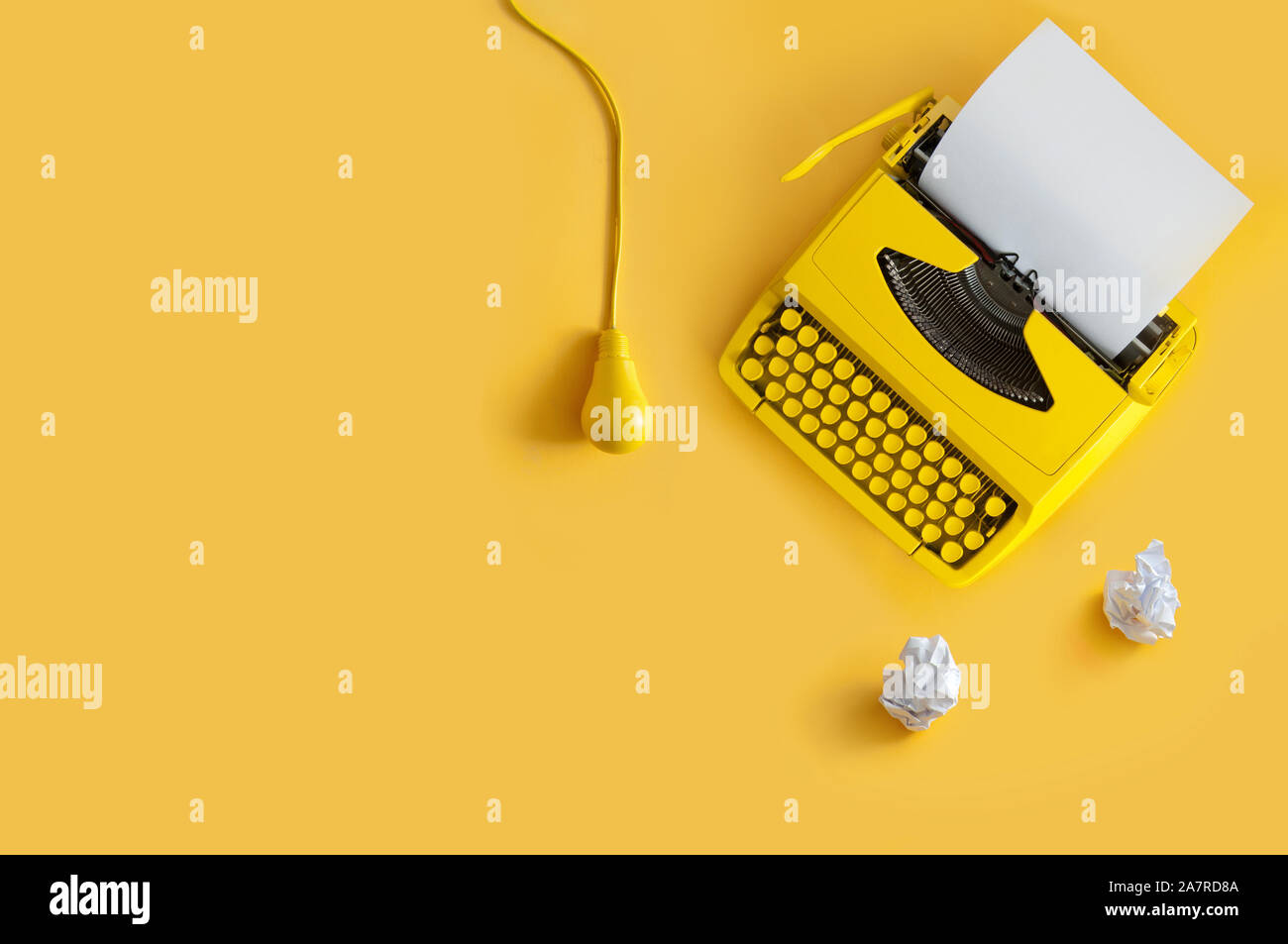 Orange retro typewriter on paper background with light bulb ...