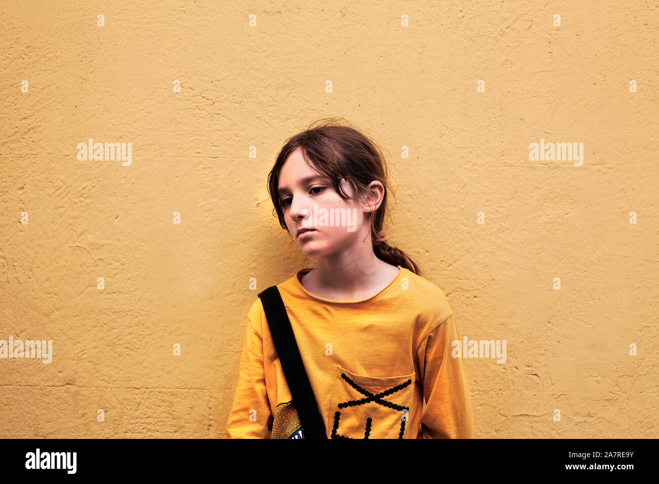 Moody boy by wall Stock Photo - Alamy