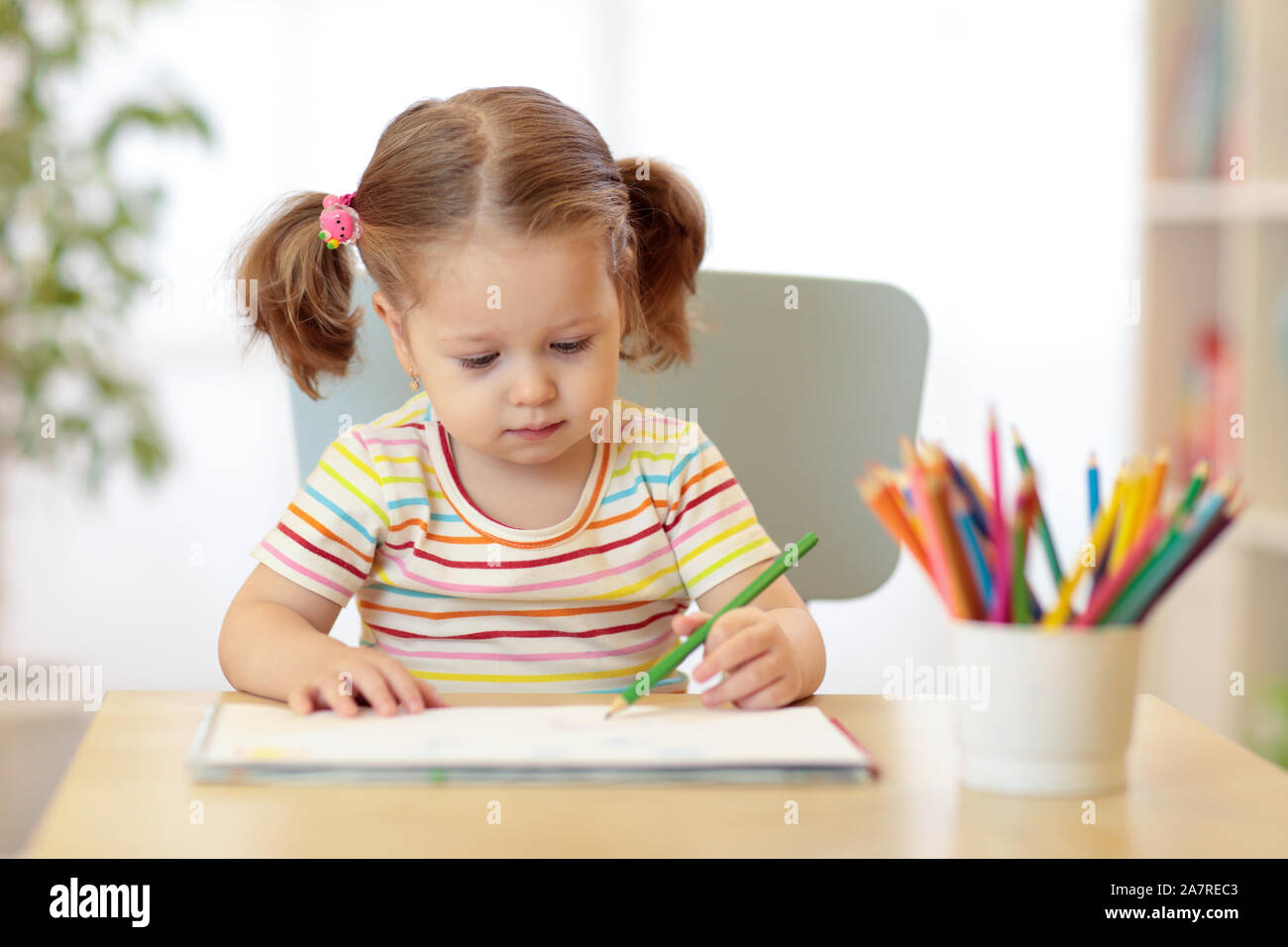 Attractive little girl writing in hi-res stock photography and images ...