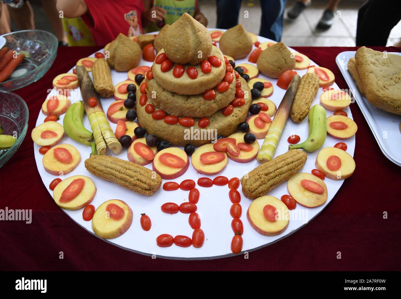 Tourists use fodder and fruits to make a birthday cake for giant panda ...