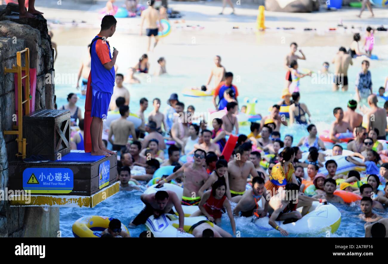 Chinese holidaymakers crowd a swimming pool at a water park to escape ...