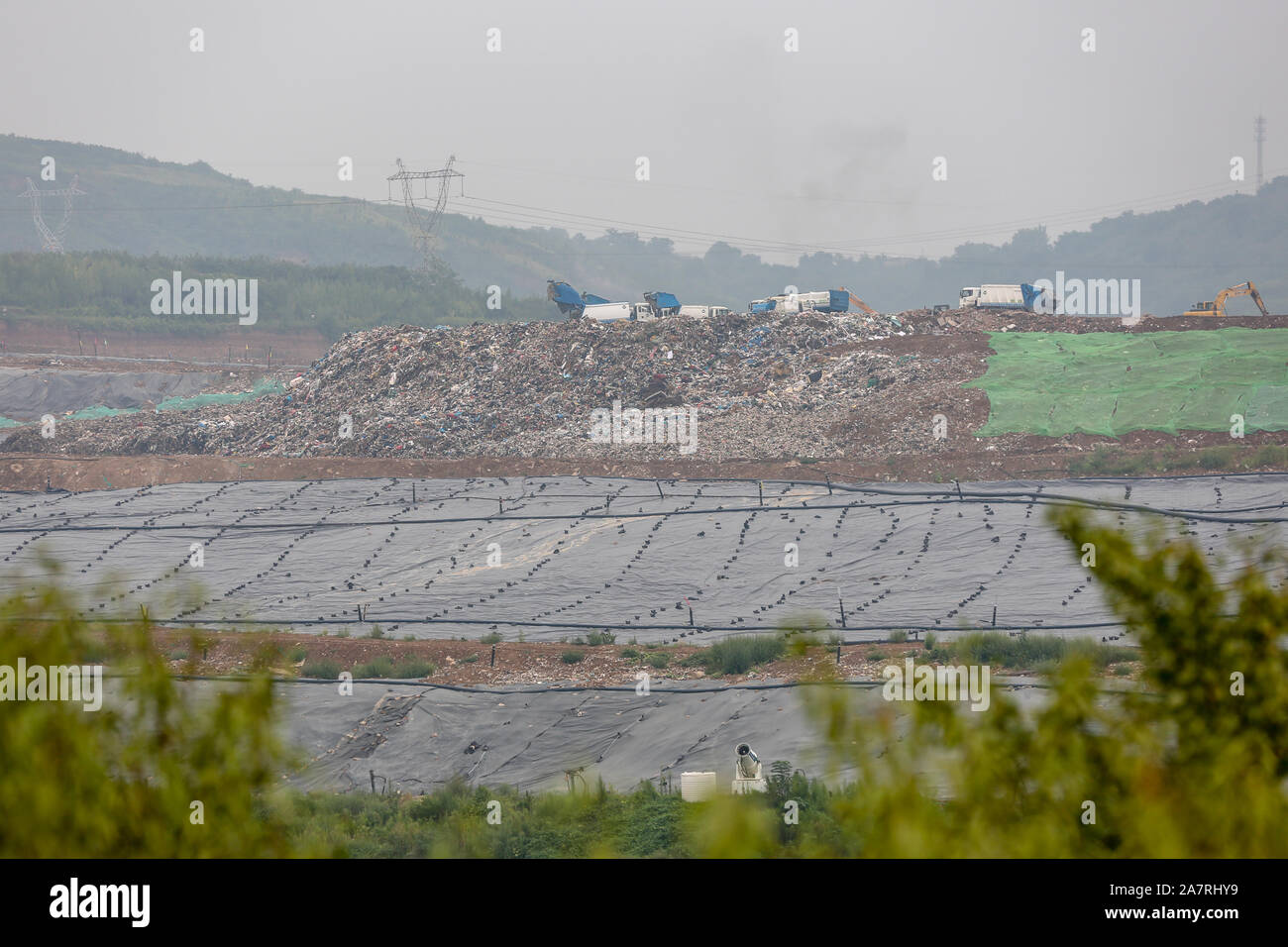 Chinese workers sort out and bury kitchen waste at the Jiangcungou ...
