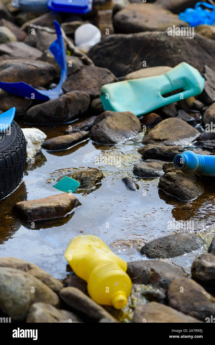 Plastic waste styrofoam and old car tire on ocean shore. Environmental ...