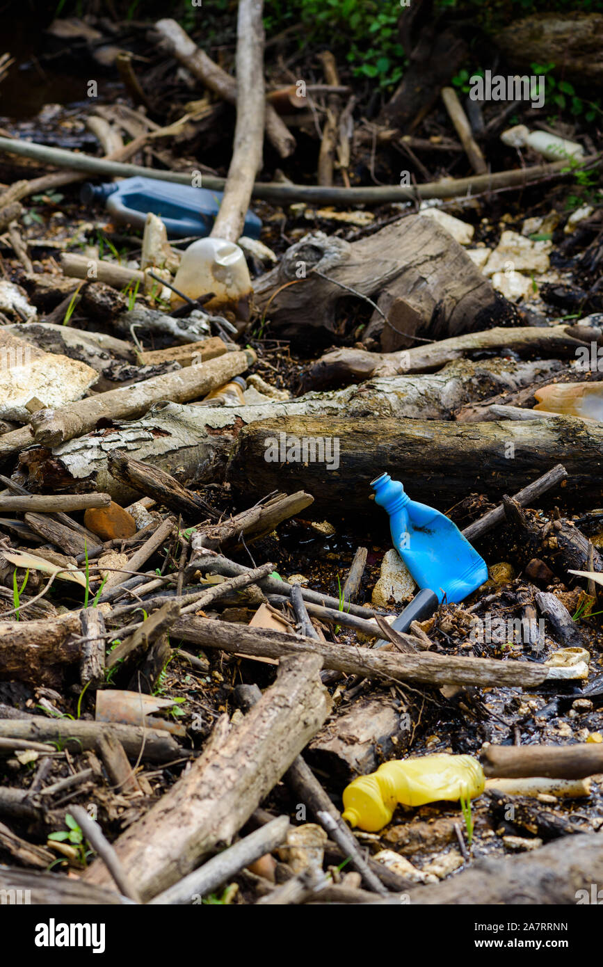 Plastic waste pollution muddy puddle with bottles and styrofoam on ...