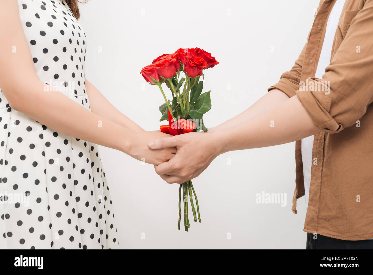 Beautiful young woman hugging her boyfriend and holding nice bouquet of ...