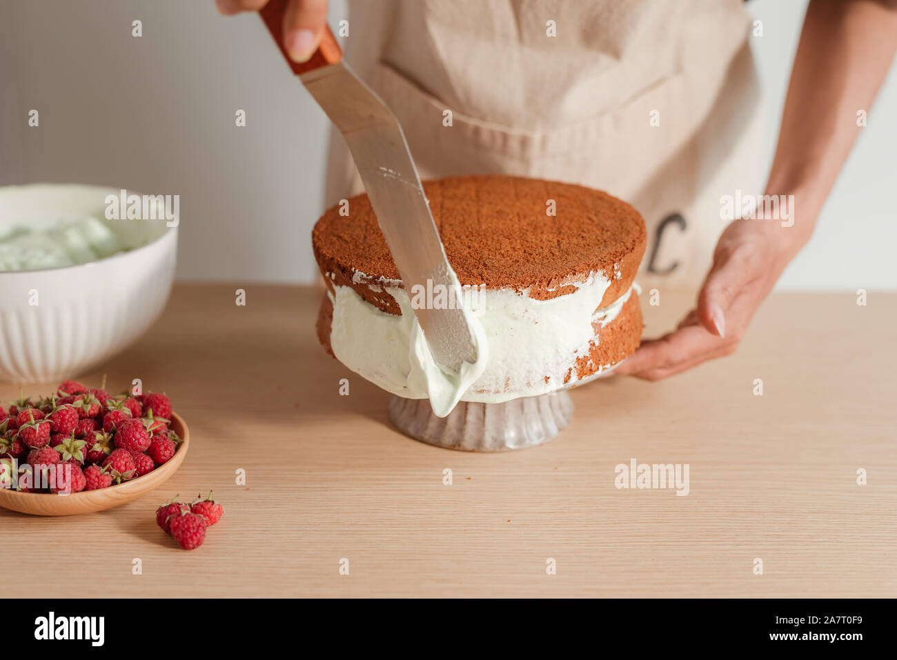 Pastry chef puts the cream on the Cakes. Process cooking sponge cake ...