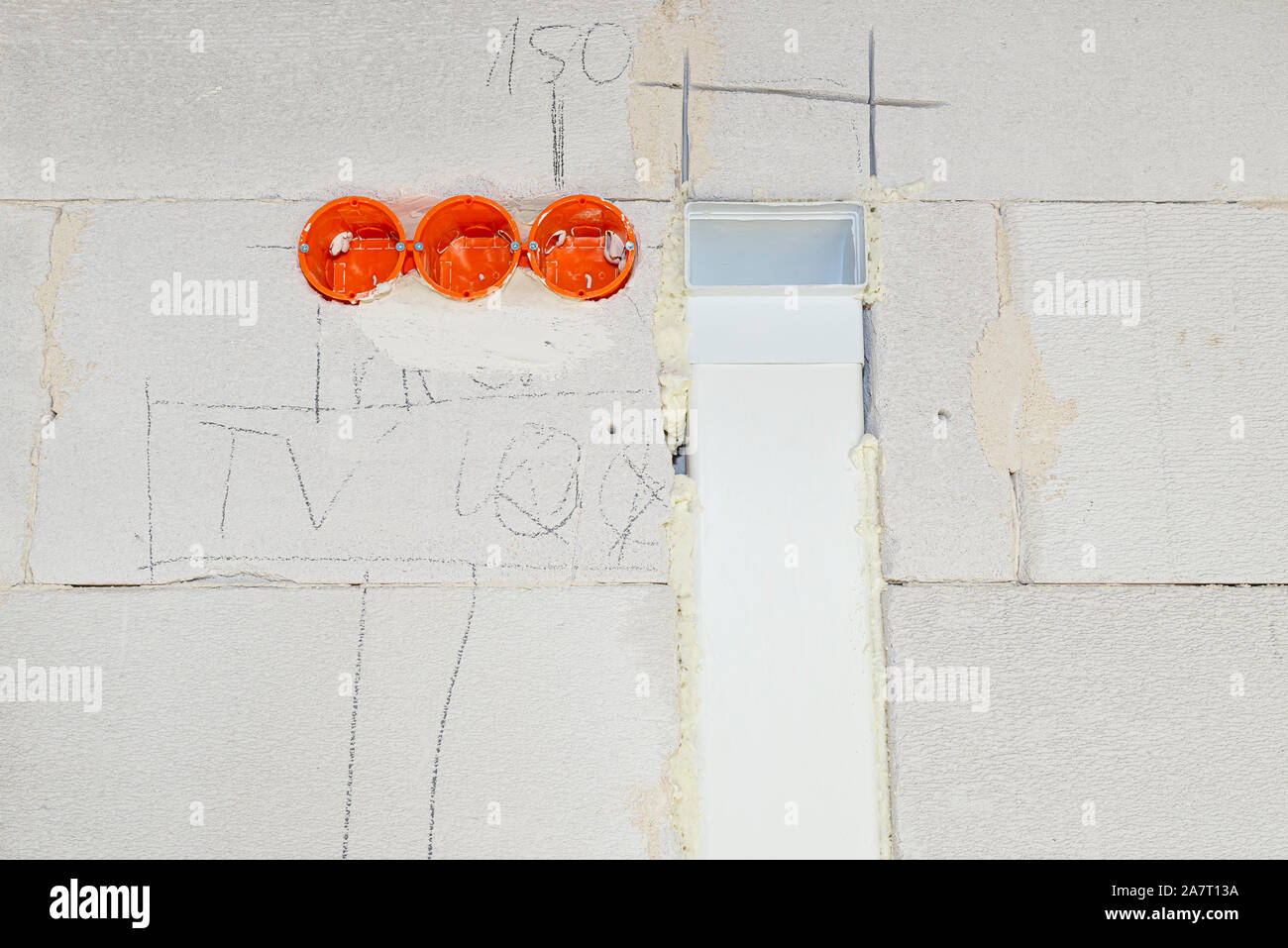 Orange, round junction box mounted in the white wall with protruding ...