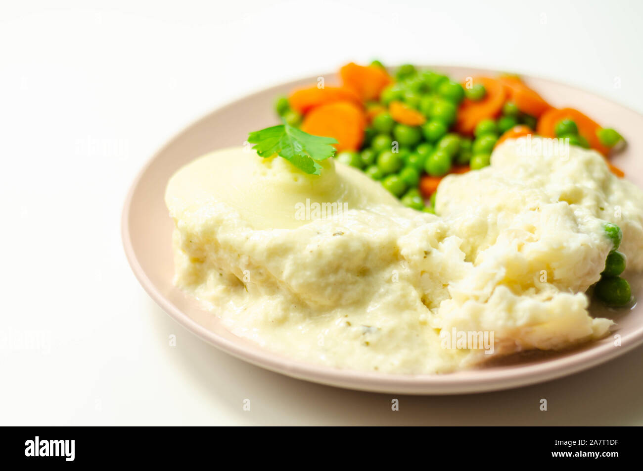 Cod fillet with a creamy cheese sauce, with mashed potato, peas and ...