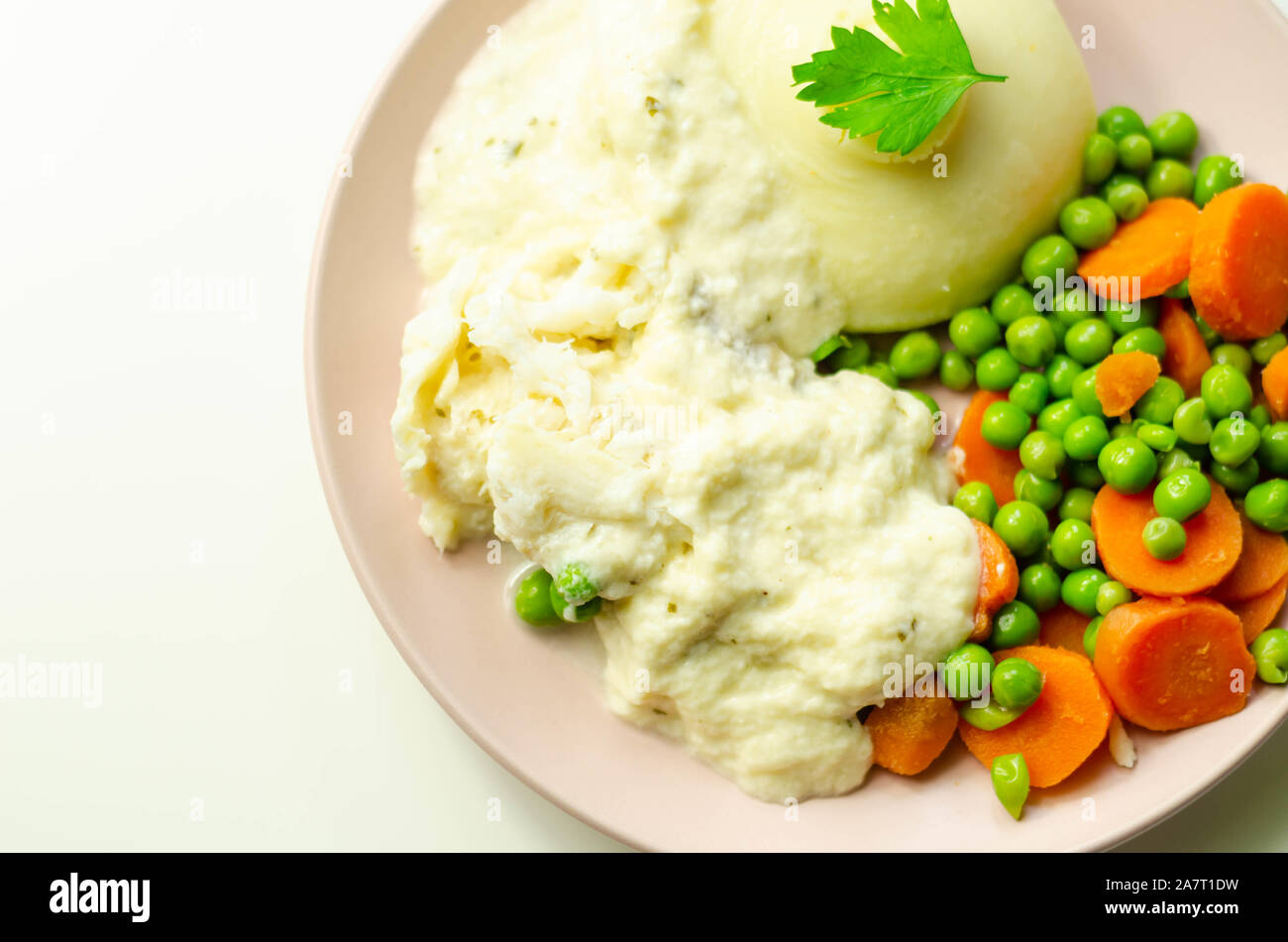 Cod fillet with a creamy cheese sauce, with mashed potato, peas and ...