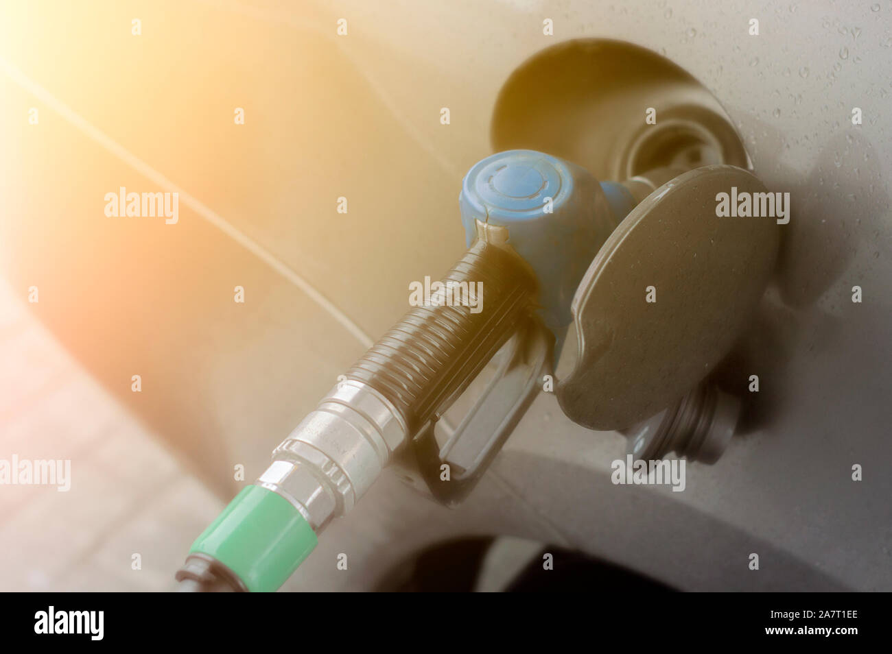 Refueling gun in the neck of the gas tank of a car at a gas station ...