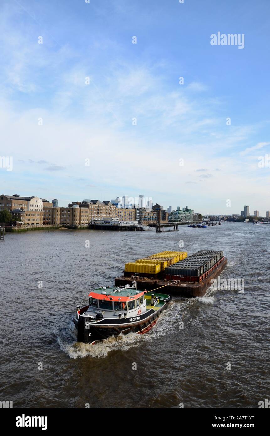 Boat towing shipping containers towards Tower Bridge on River Thames ...
