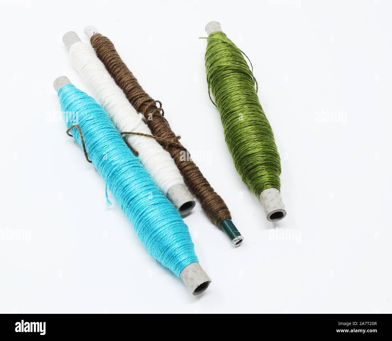 weaving paper bobbins, partly filled with blue, white, brown and green ...