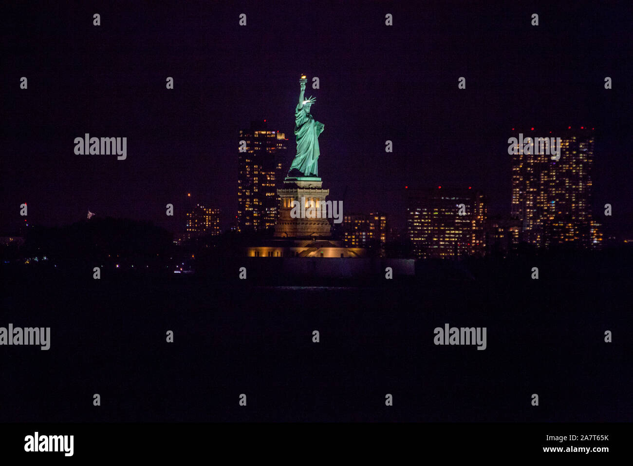 Statue of Liberty at night photographed from the Staten Island Ferry ...