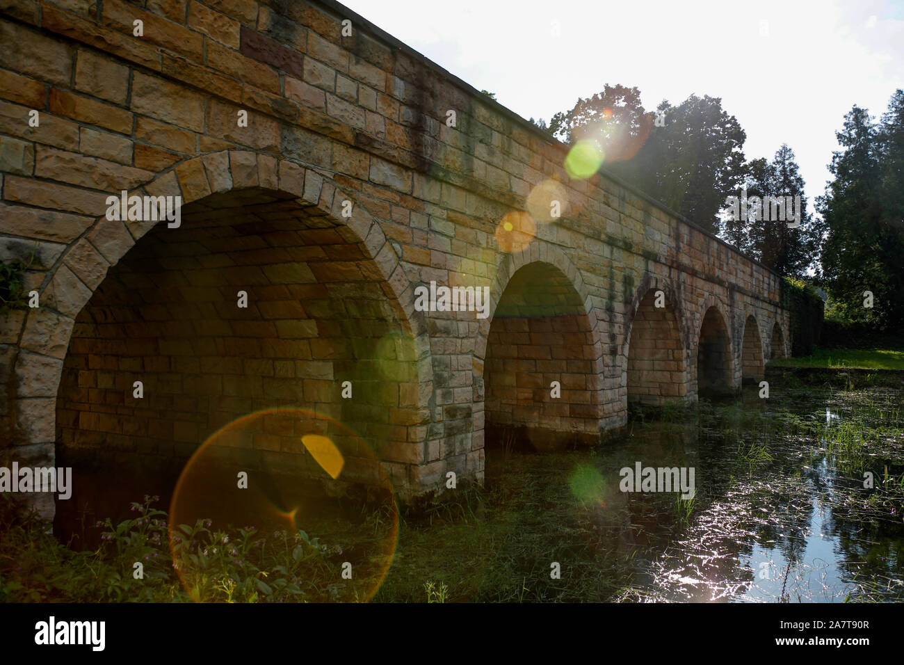 old bridge over pond with lens flares Stock Photo - Alamy