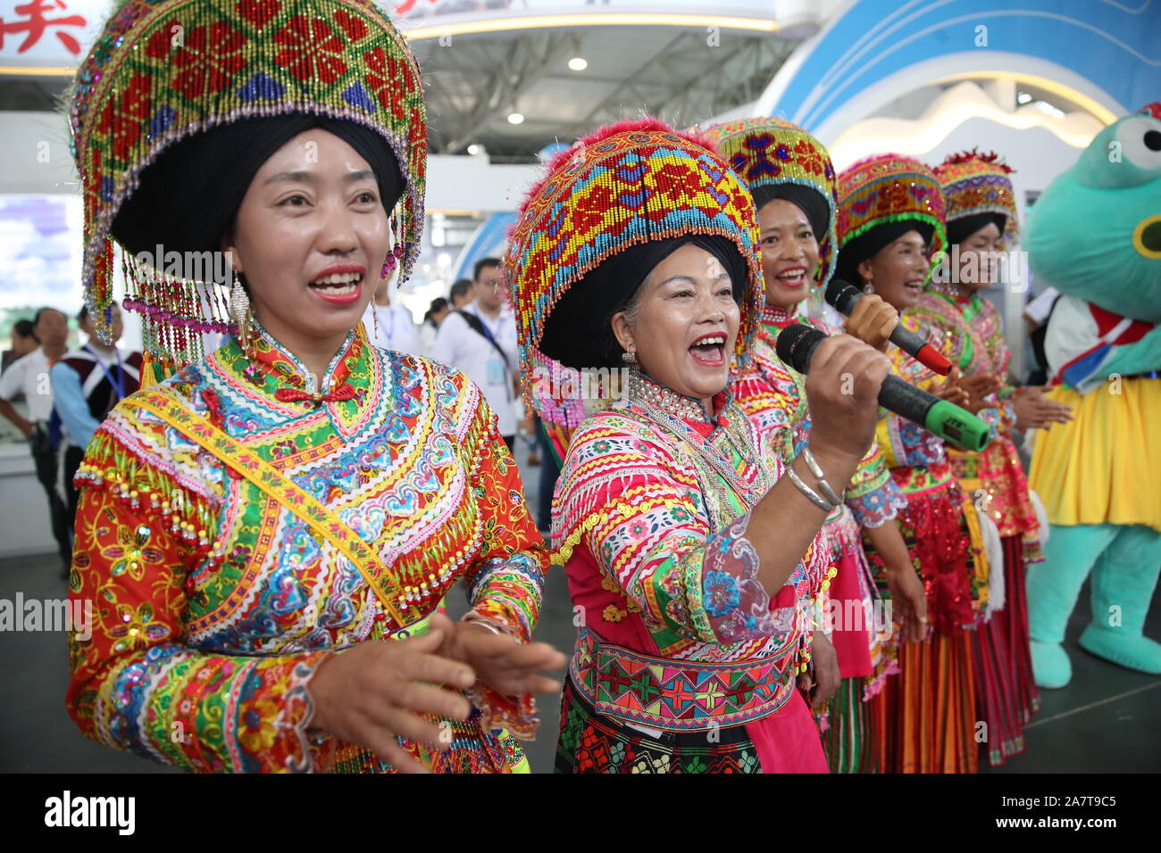 Chinese ethnic people dressed in traditional costumes perform during ...