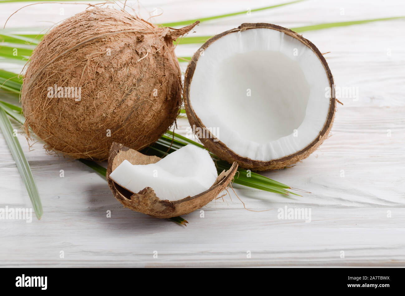 Coconut and shell pieces on white wooden table Stock Photo - Alamy