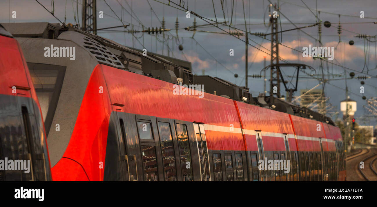 red passenger train in the evening Stock Photo - Alamy