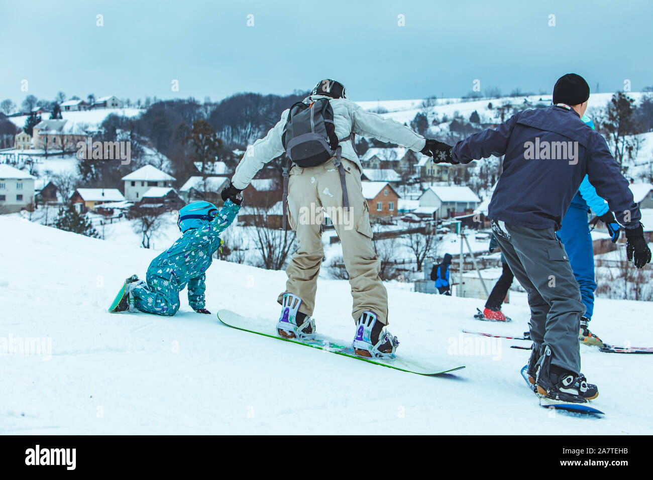 mother teaching little girl to snowboarding Stock Photo - Alamy