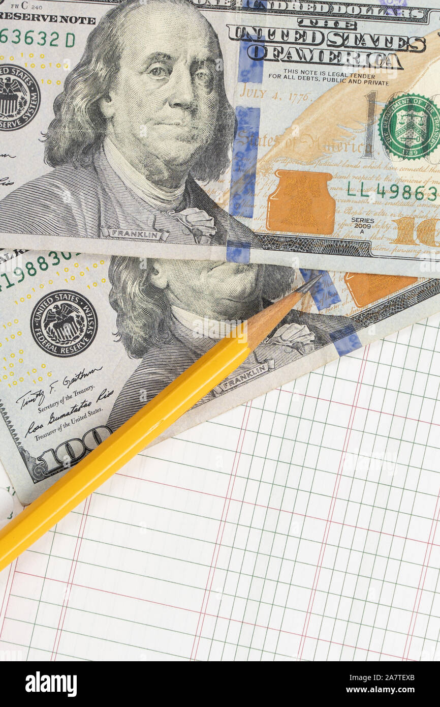 budget concept with lined accounting paper and 2 one hundred bills with ...