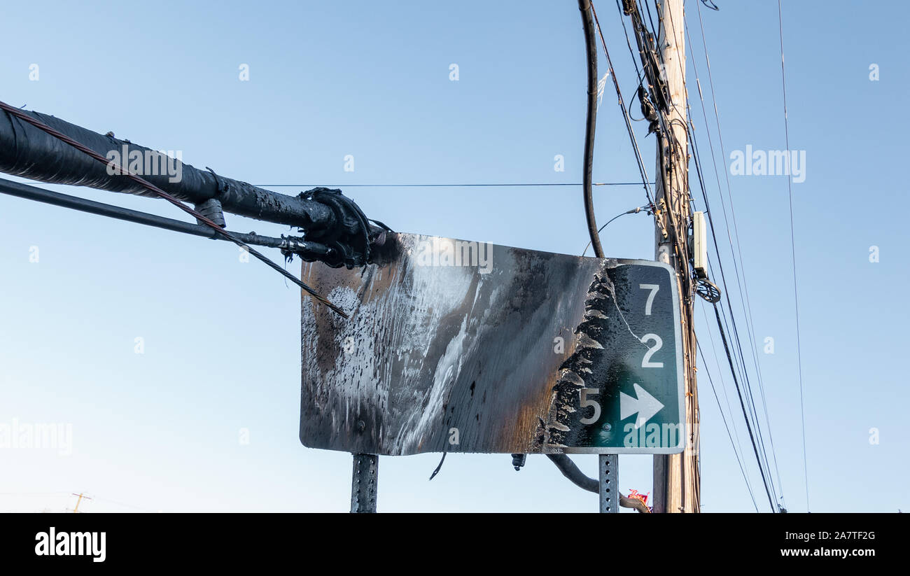 road sign is damaged by thick black power line that came down on it and ...