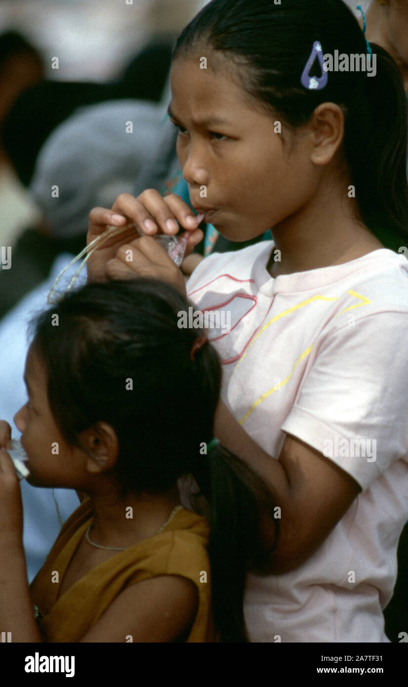 Two young girls watching a traditional Khmer boat race on the River ...