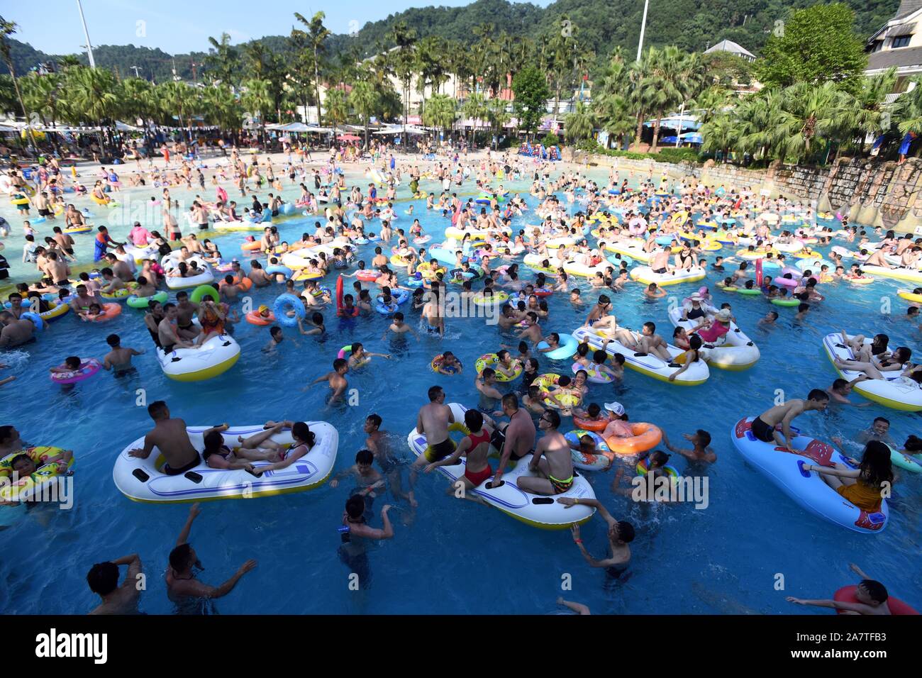 Chinese holidaymakers crowd a swimming pool at a water park to escape ...