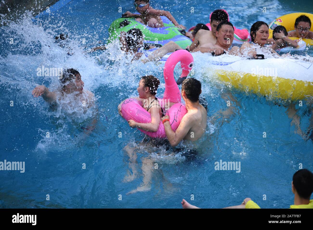 Chinese holidaymakers crowd a swimming pool at a water park to escape ...