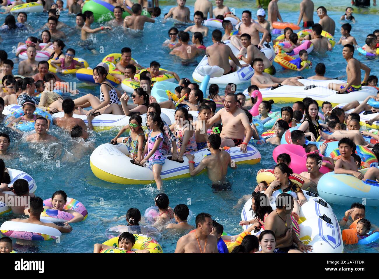 Chinese holidaymakers crowd a swimming pool at a water park to escape ...
