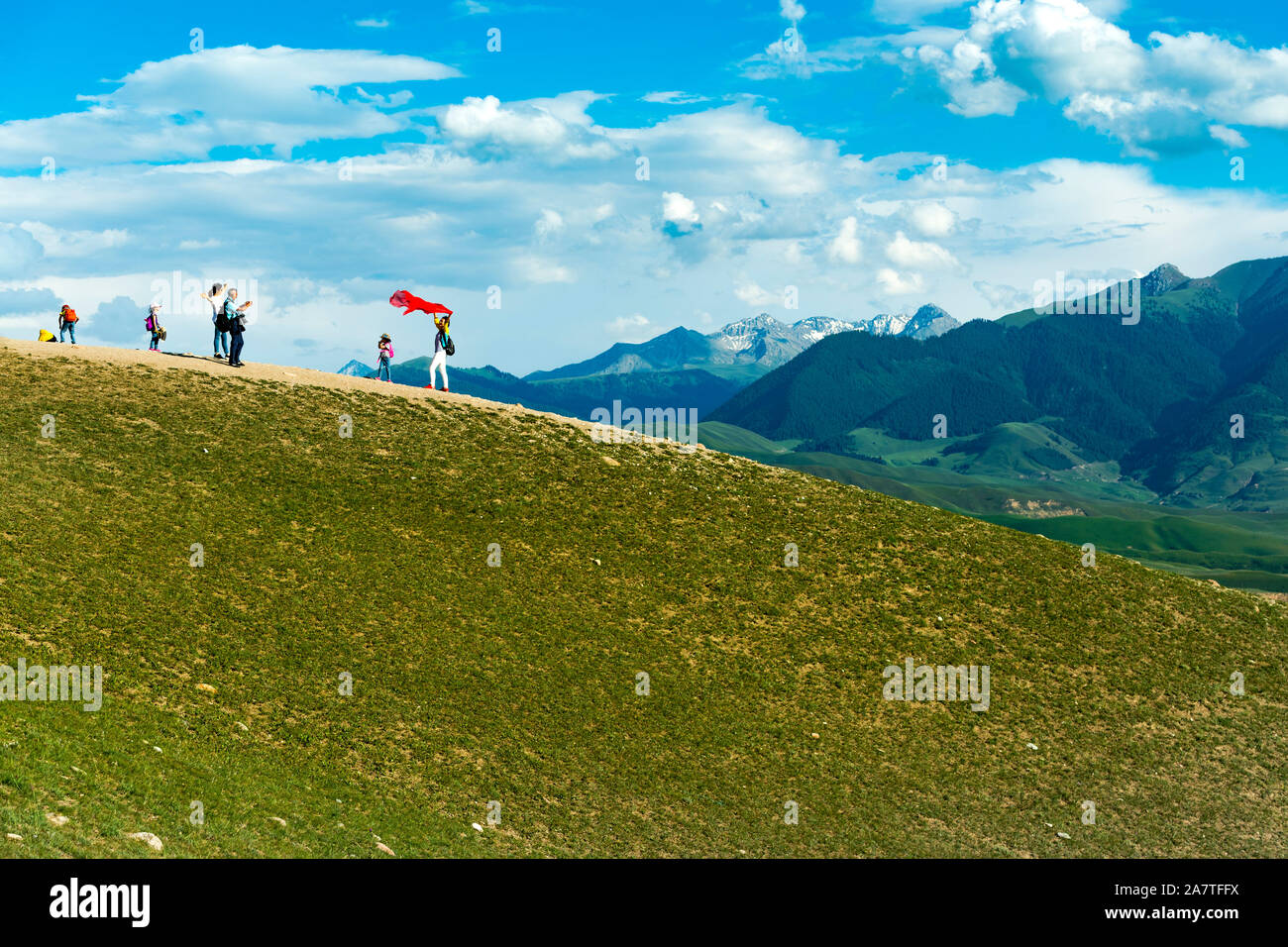 Tourists pose for photos on the Kalajun Grassland in Tekes county, Ili ...