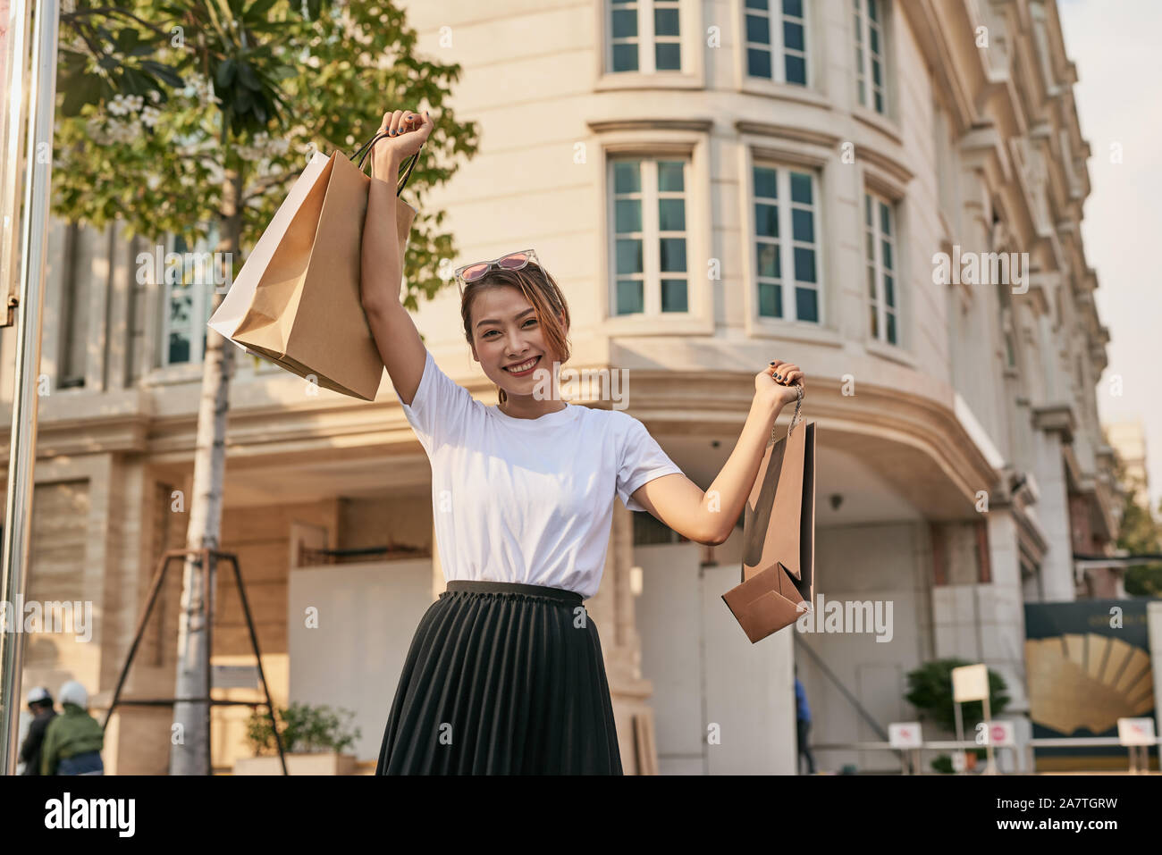 Happy young woman walking after shopping on mall sale Stock Photo - Alamy