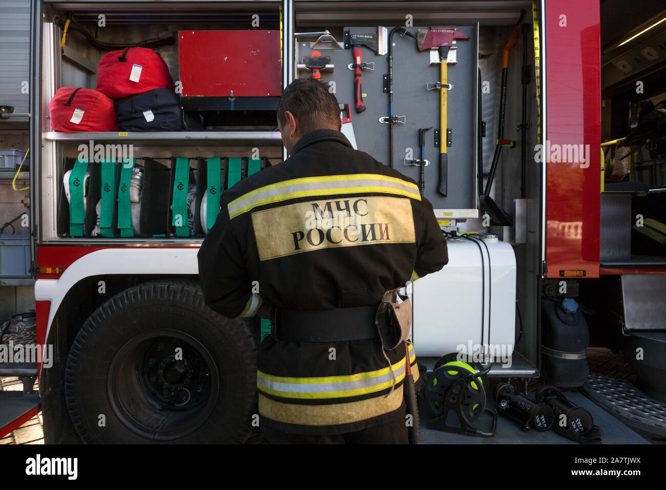 Russian fireman walks near a fire truck while extinguishing a fire ...