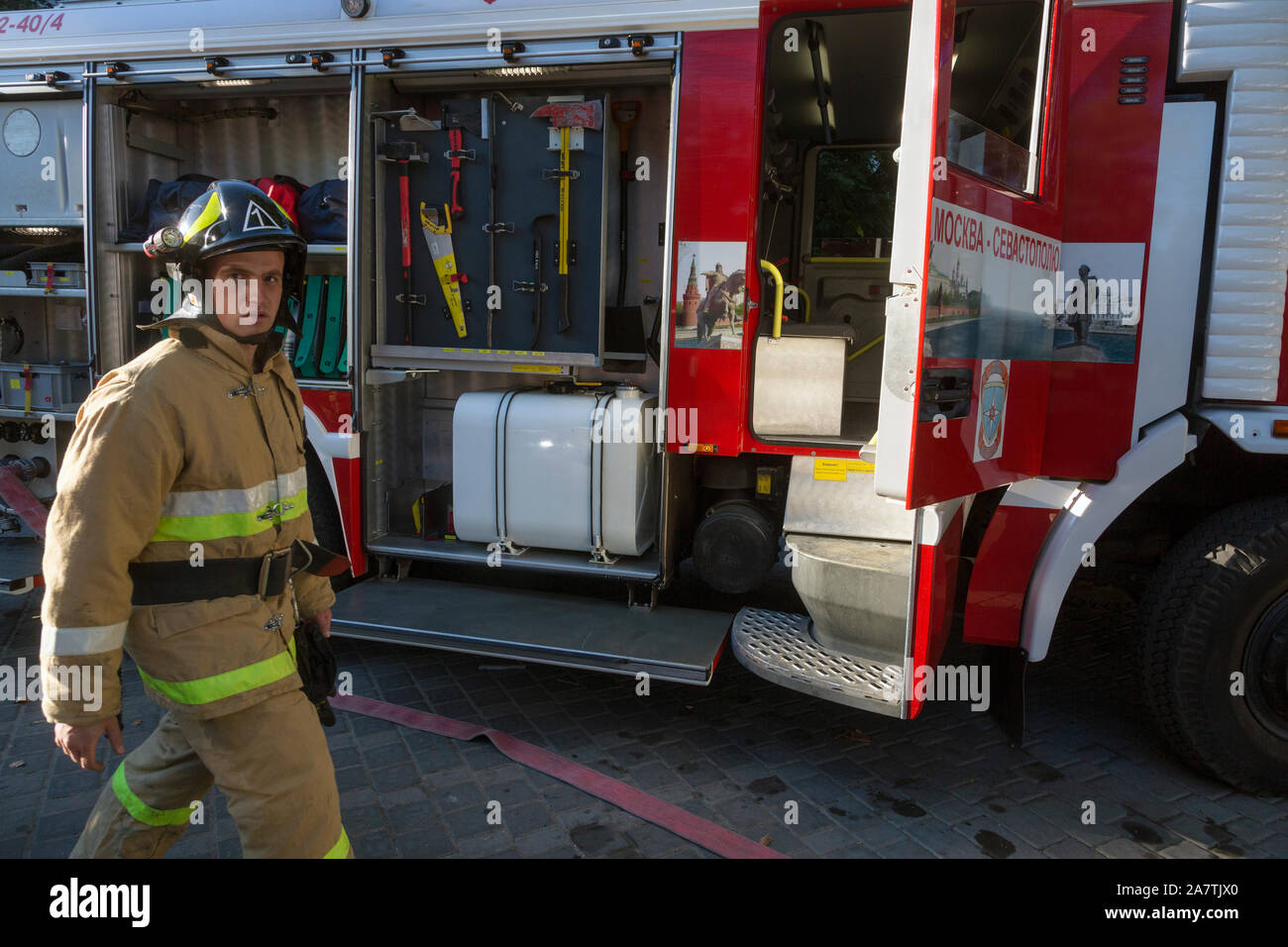 Russian fireman walks near a fire truck while extinguishing a fire ...