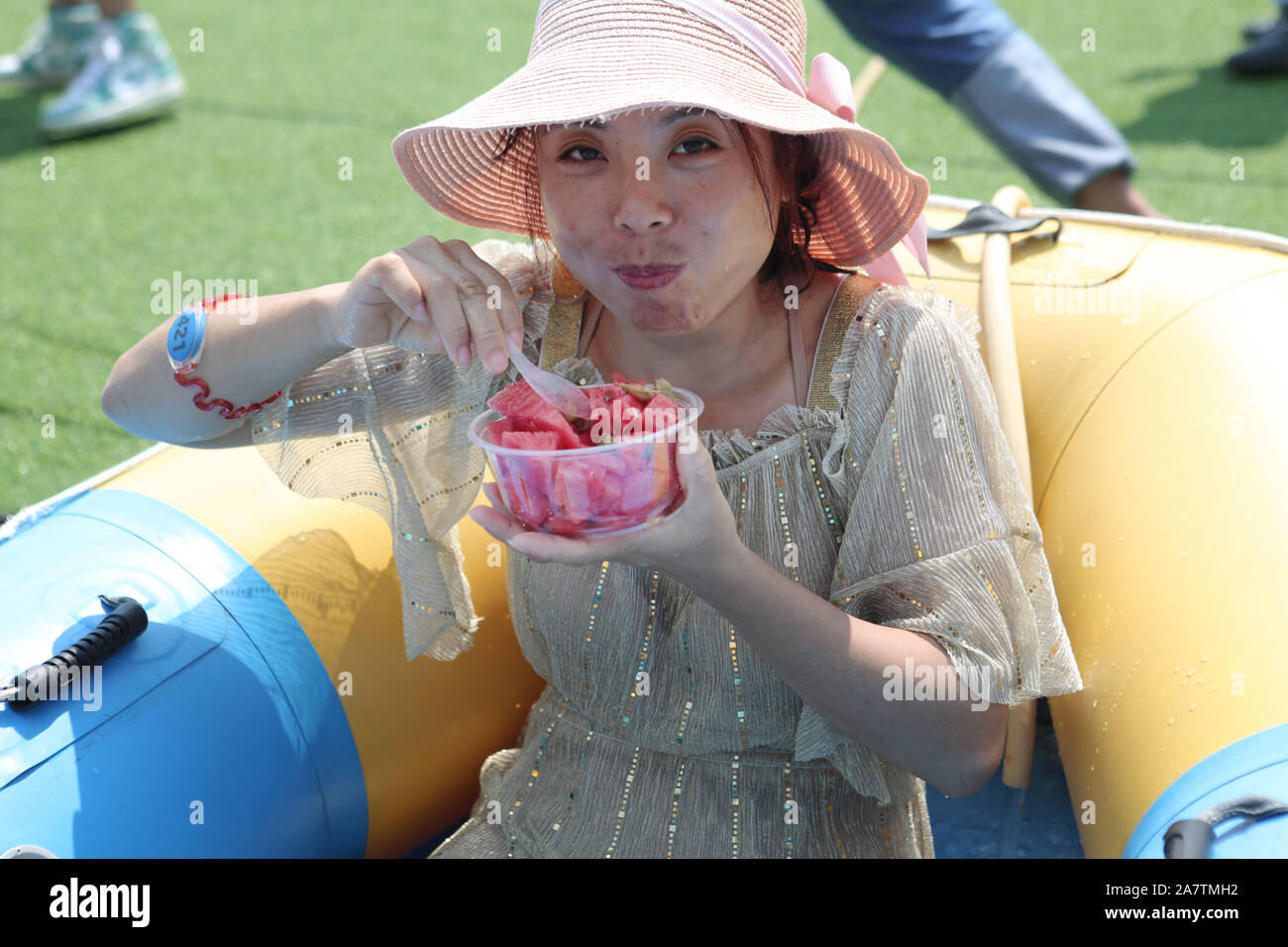 A tourist enjoys watermelon added with zhacai, or pickled mustard stems ...
