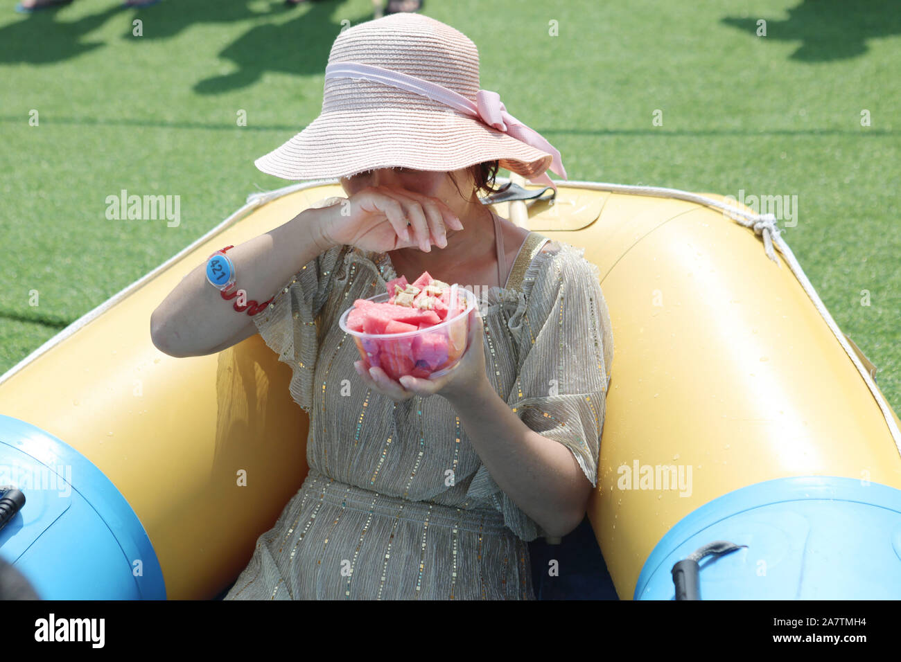 A tourist enjoys watermelon added with zhacai, or pickled mustard stems ...