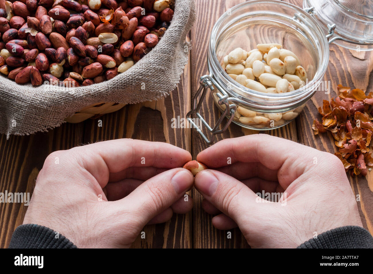 man cleans roasted peanuts Stock Photo - Alamy