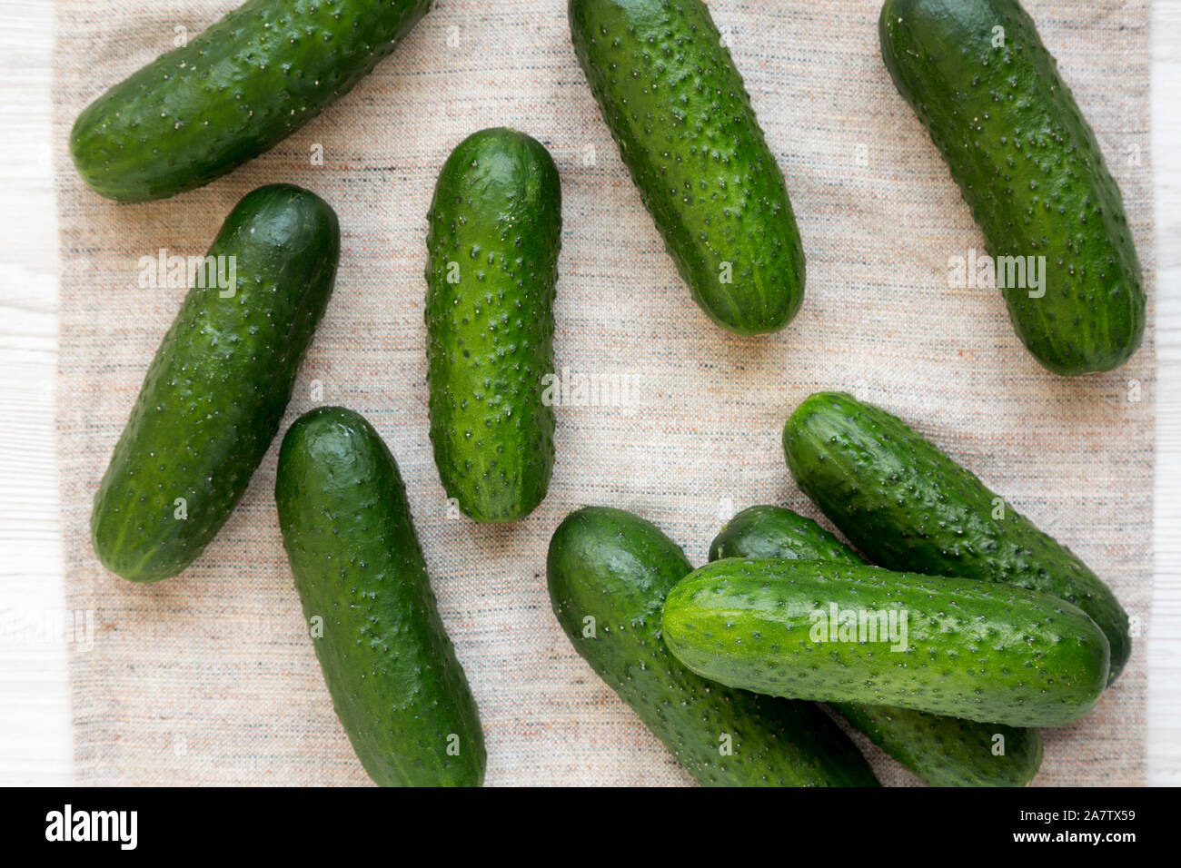 Ripe organic mini baby cucumbers on cloth, overhead view. Flat lay, top ...